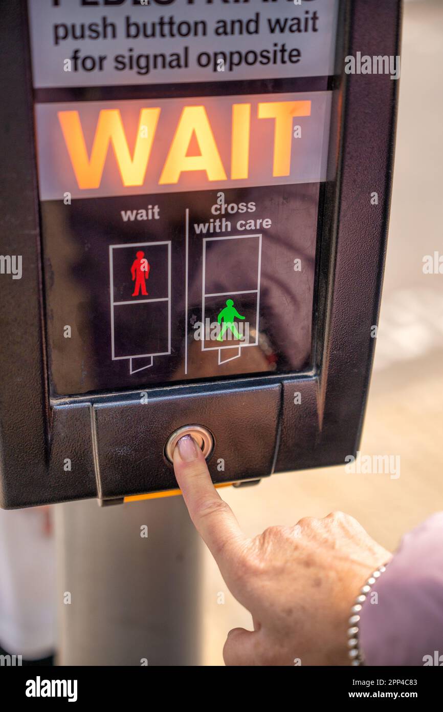 Woman finger pushing pedestrian crossing signal Stock Photo - Alamy