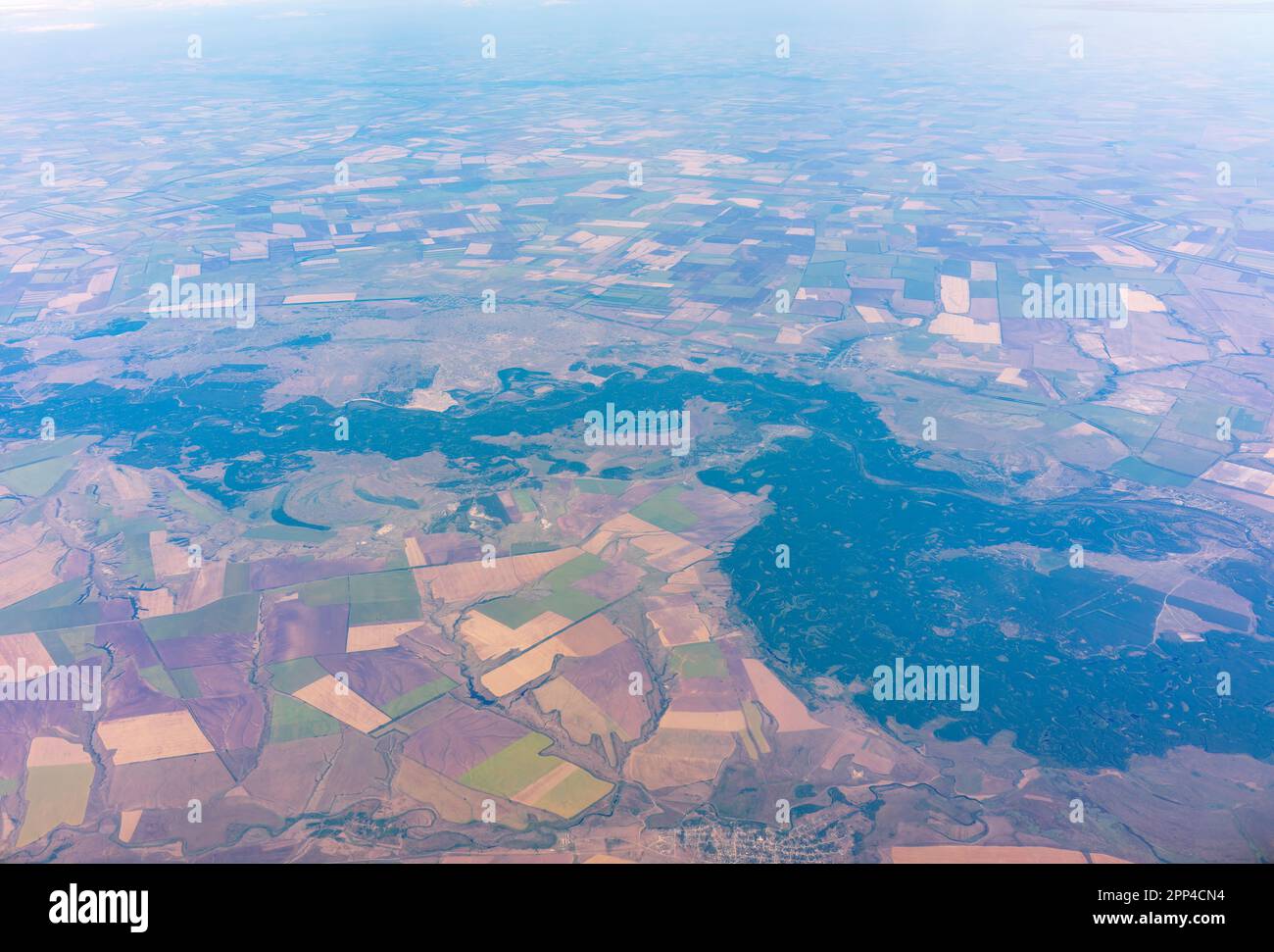Aerial view from airplane window above green ground. View from the ...