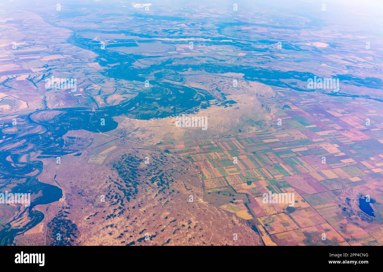 Aerial view from airplane window above green ground. View from the ...