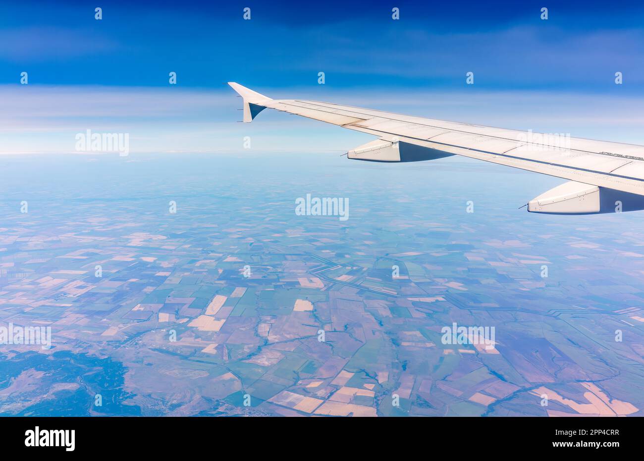 Aerial view from airplane window above green ground. View from the ...