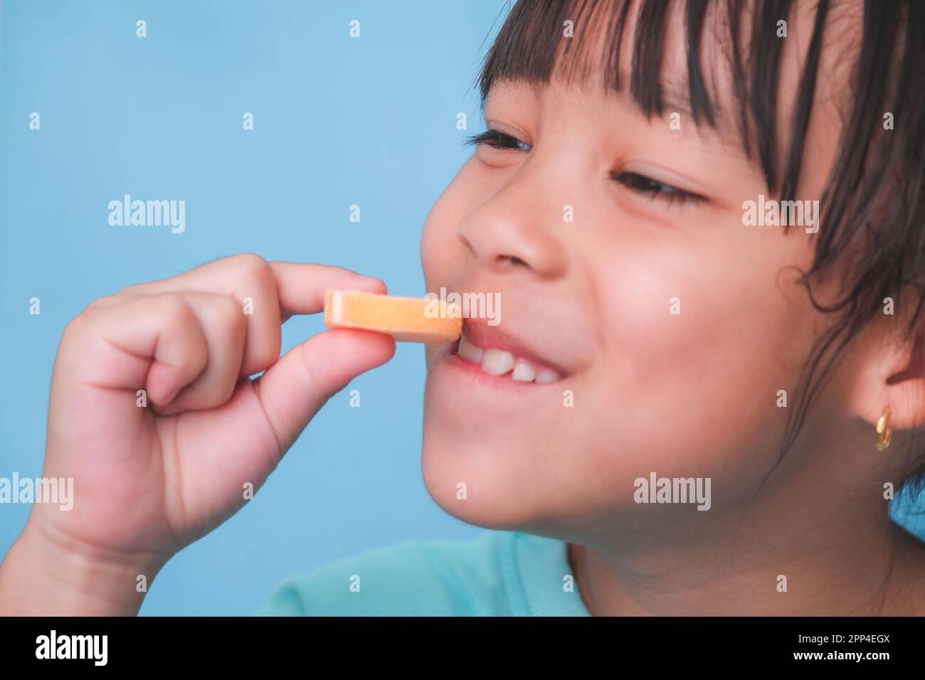 Smiling cute little girl eating sweet gelatin with sugar added isolated ...