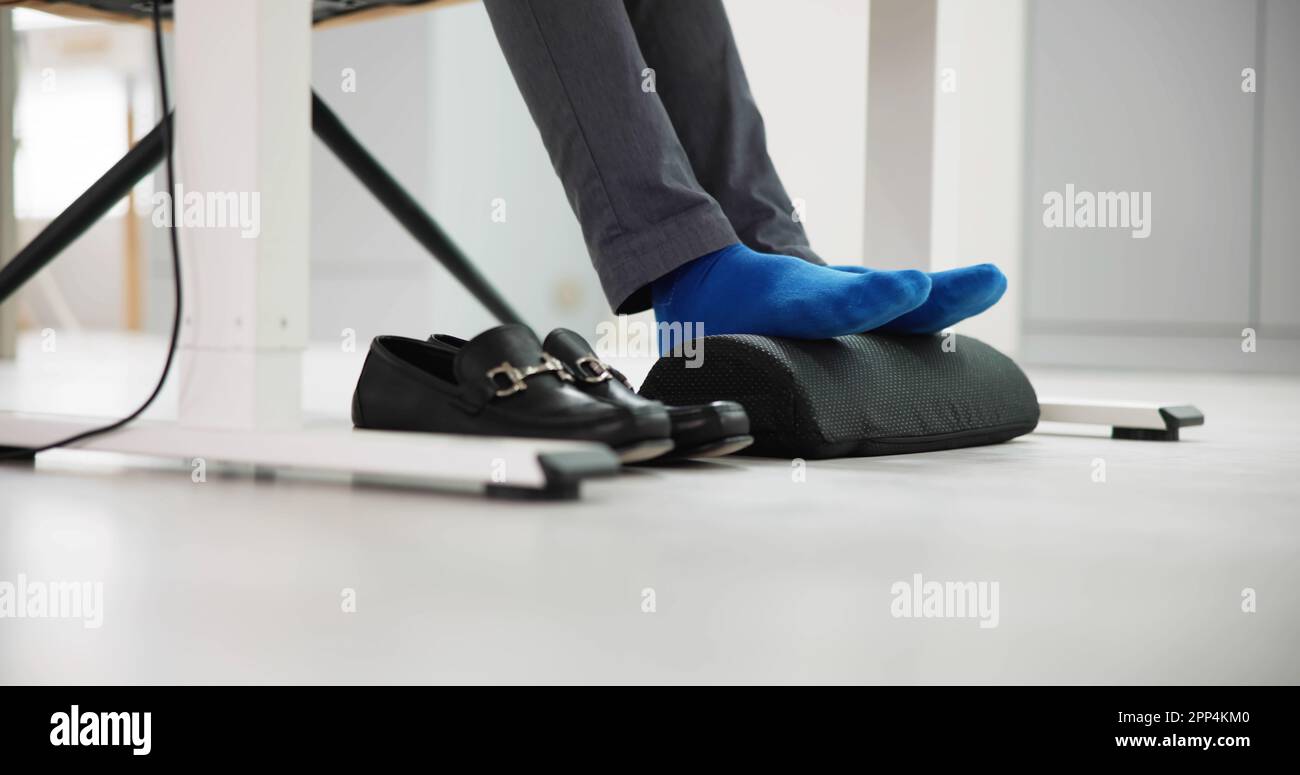 Man Using Footrest To Reduce Back Strain And Feet Fatigue Stock Photo ...