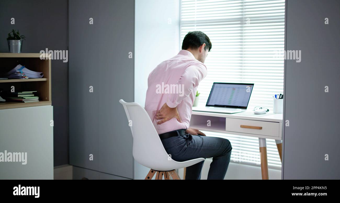 Back Pain Bad Posture Man Sitting In Office Stock Photo - Alamy