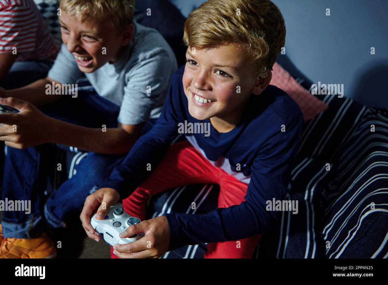 Time to go for the win. young boys playing video games Stock Photo - Alamy