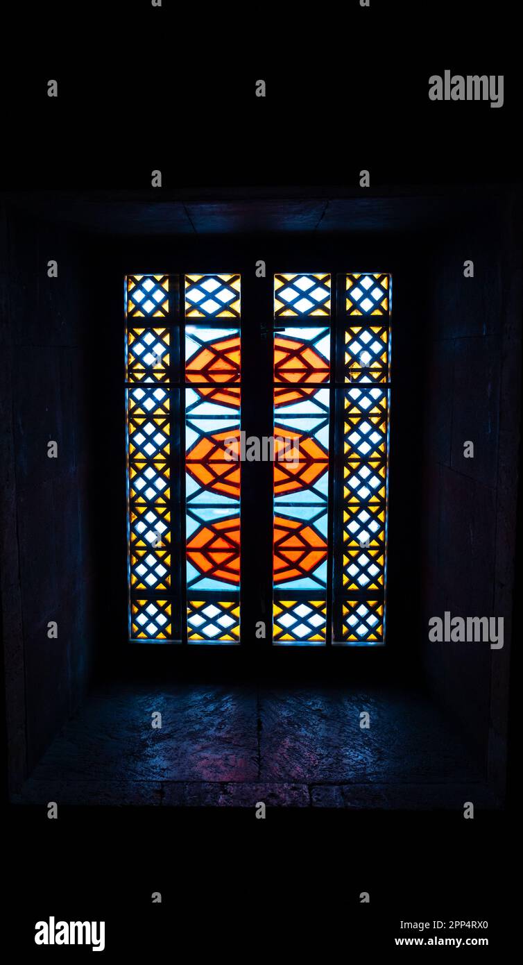 An old window with mosaics, multicolored glasses of red, blue, yellow ...