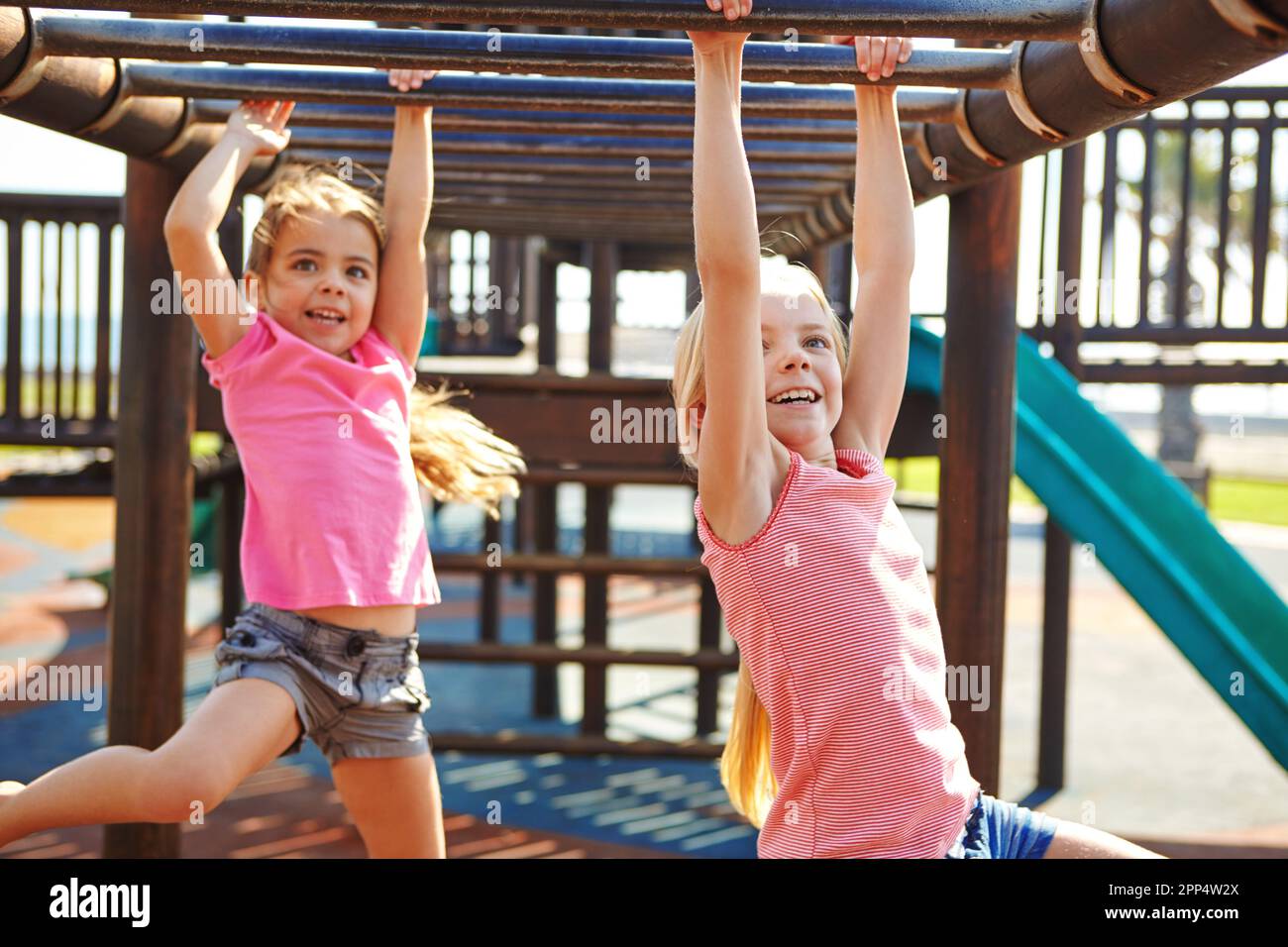 Children need the freedom and time to play. two little girls hanging on ...