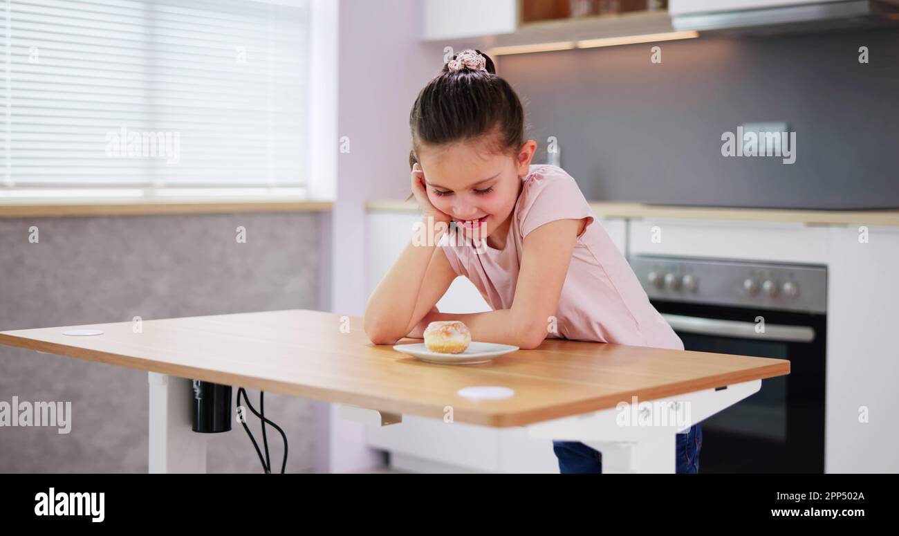 Child Looking At Cupcake In Kitchen. Self Control Test Stock Photo - Alamy