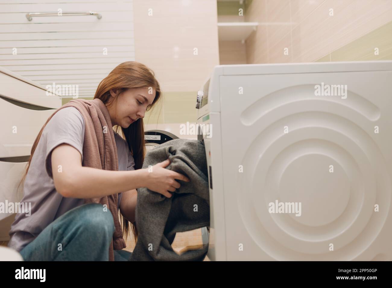 Hands loading washing machine hi-res stock photography and images - Alamy