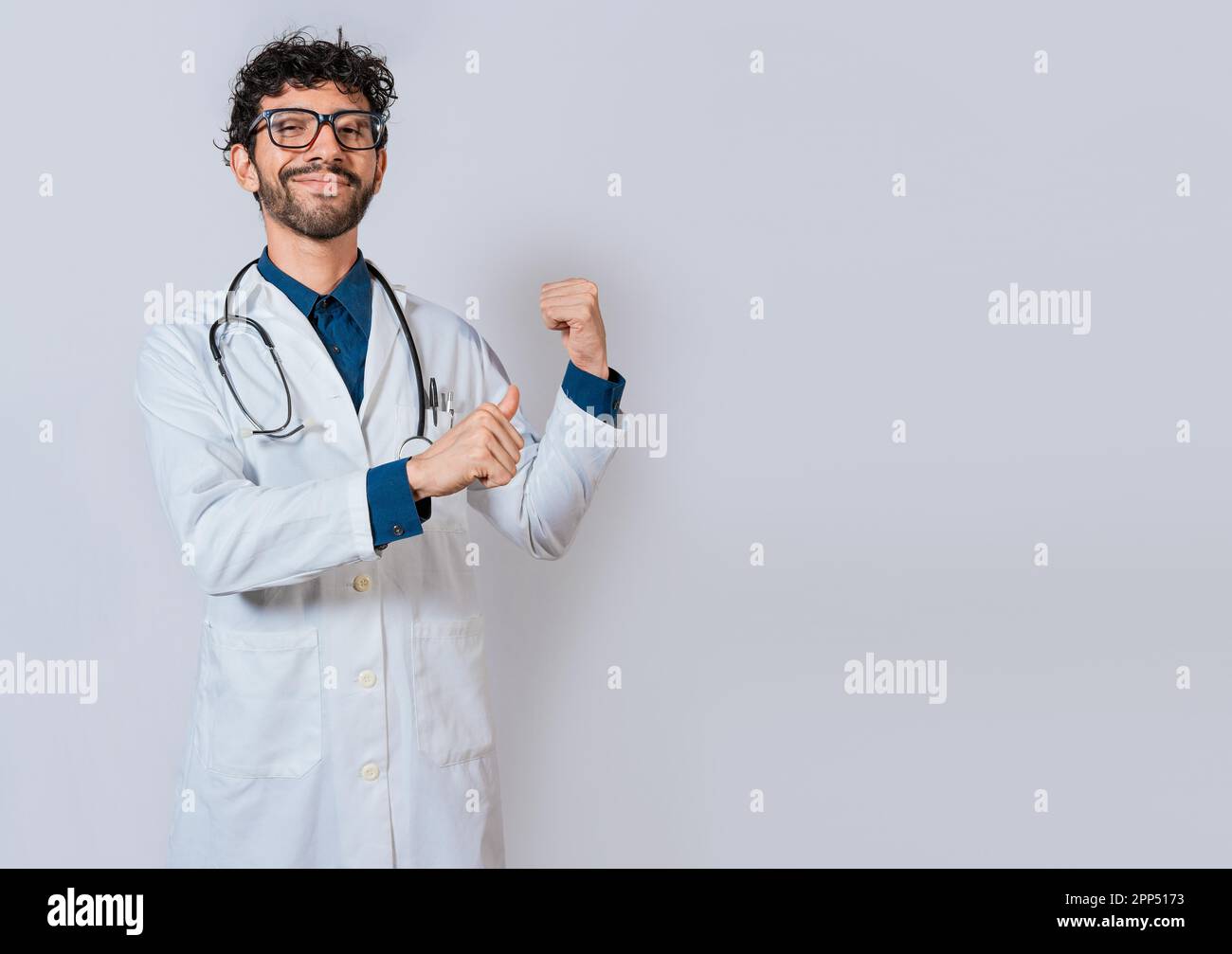 Smiling doctor pointing back isolated. Doctor pointing back with his ...