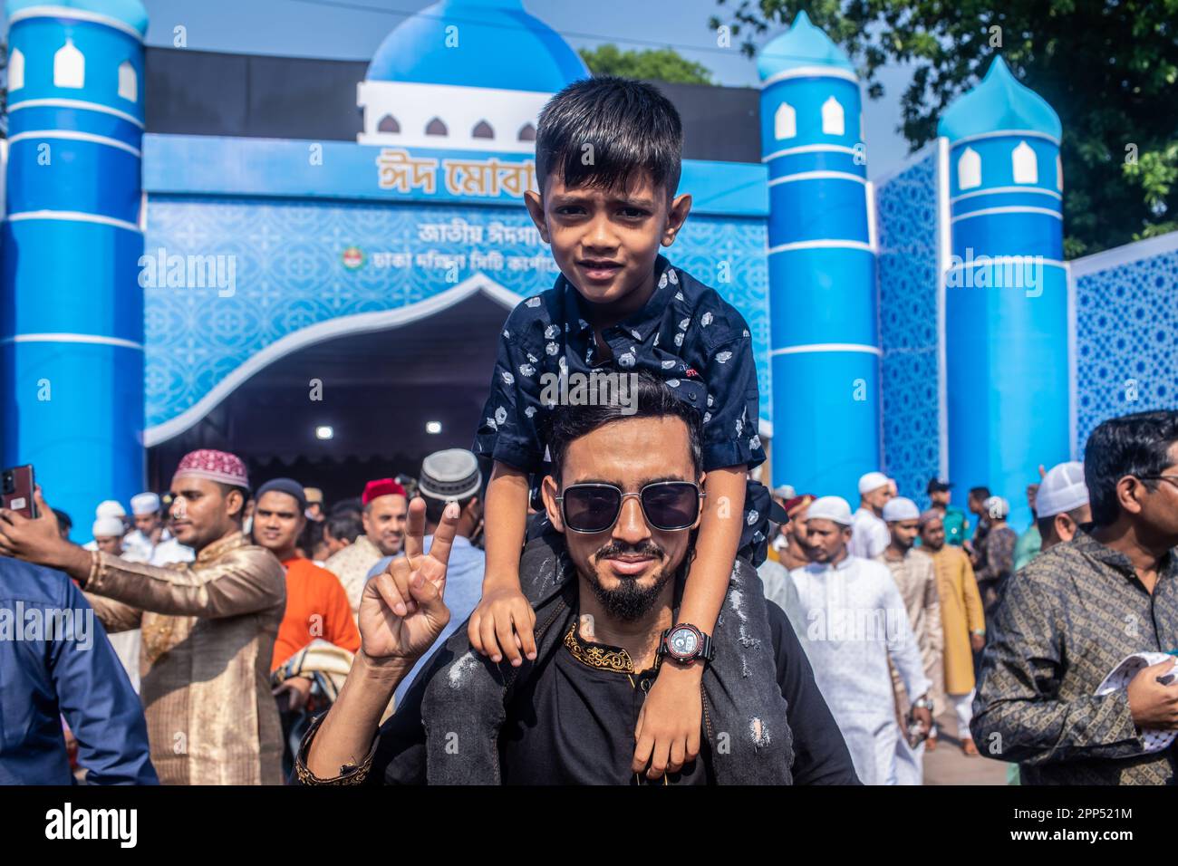 Dhaka, Bangladesh. 22nd Apr, 2023. A father arrives with his kid on his fathers shoulders at ...