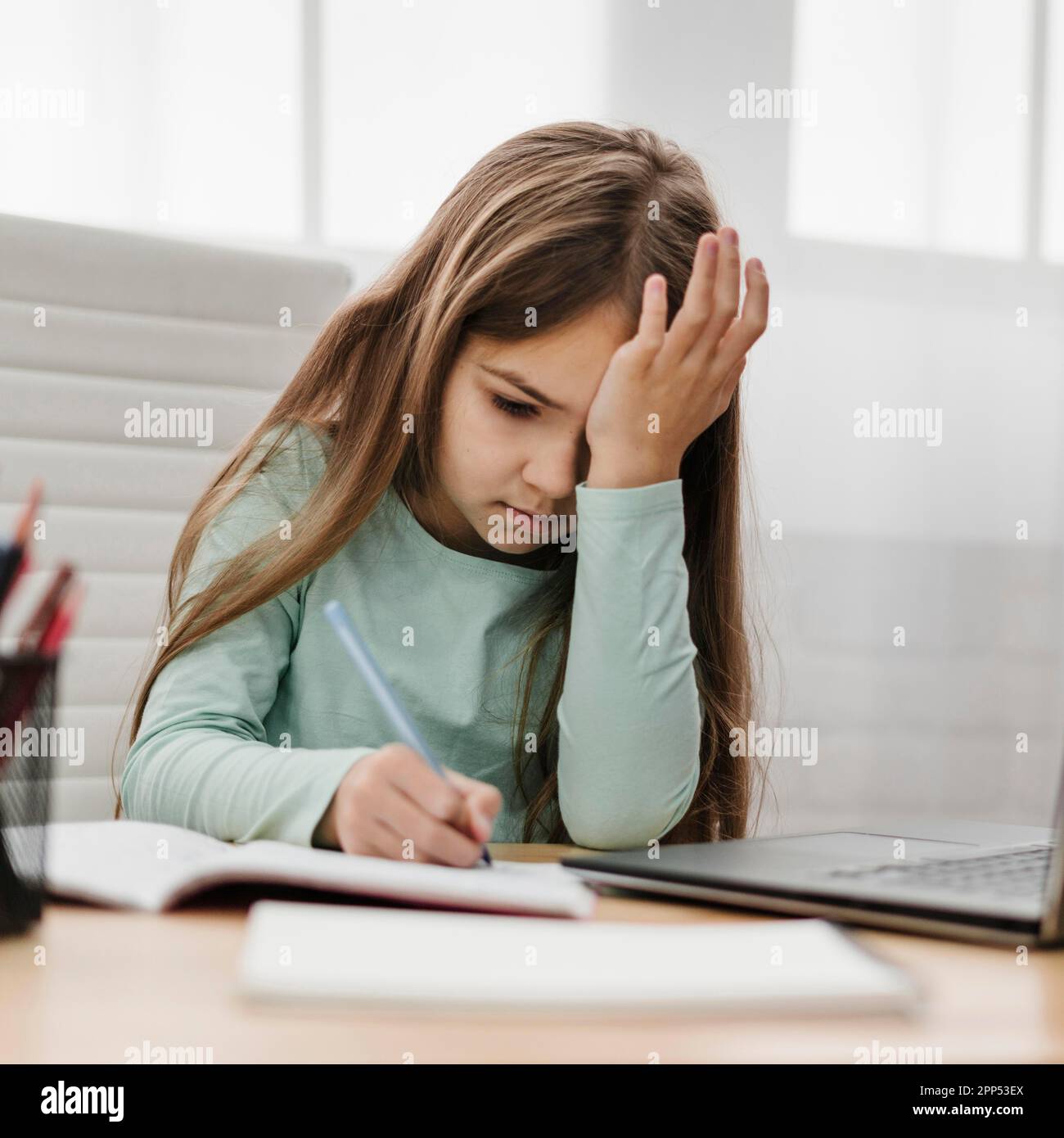 Tired girl taking notes home Stock Photo - Alamy
