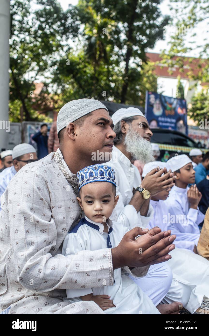 A Muslim man carrying a child offers Eid al-Fitr prayers marking the ...
