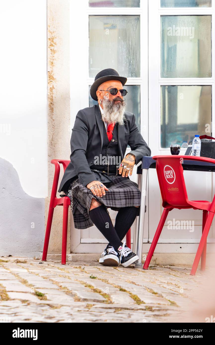 older bearded man in kilt wearing bowler hat sitting in loule portugal ...