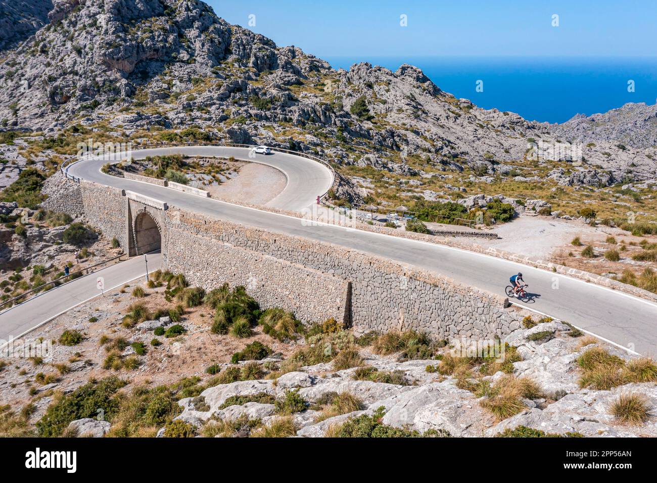 Road cyclists at the mountain pass with serpentines to Sa Colobra, Nus ...