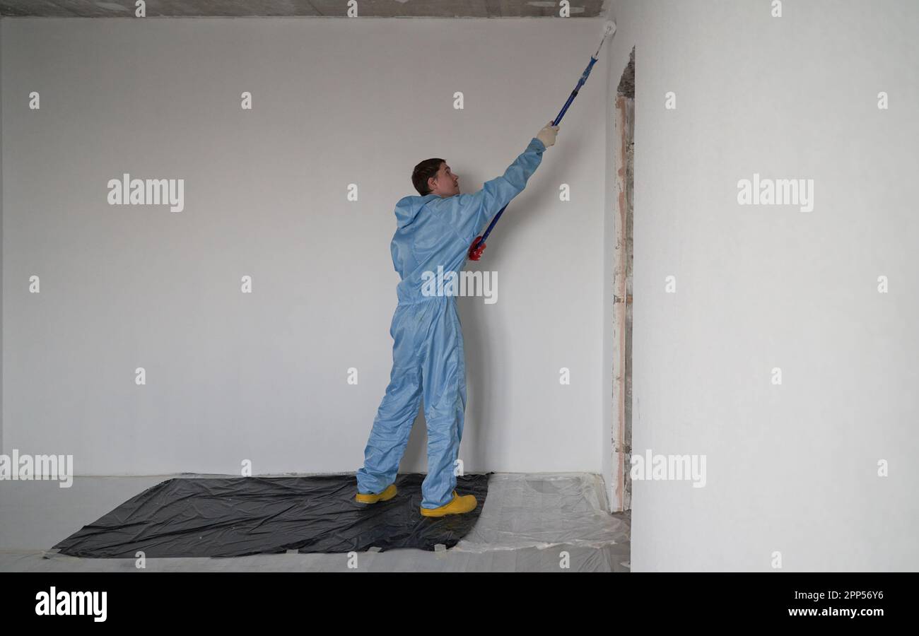 Man paints the ceiling with a roller. Concept of home makeover and ...