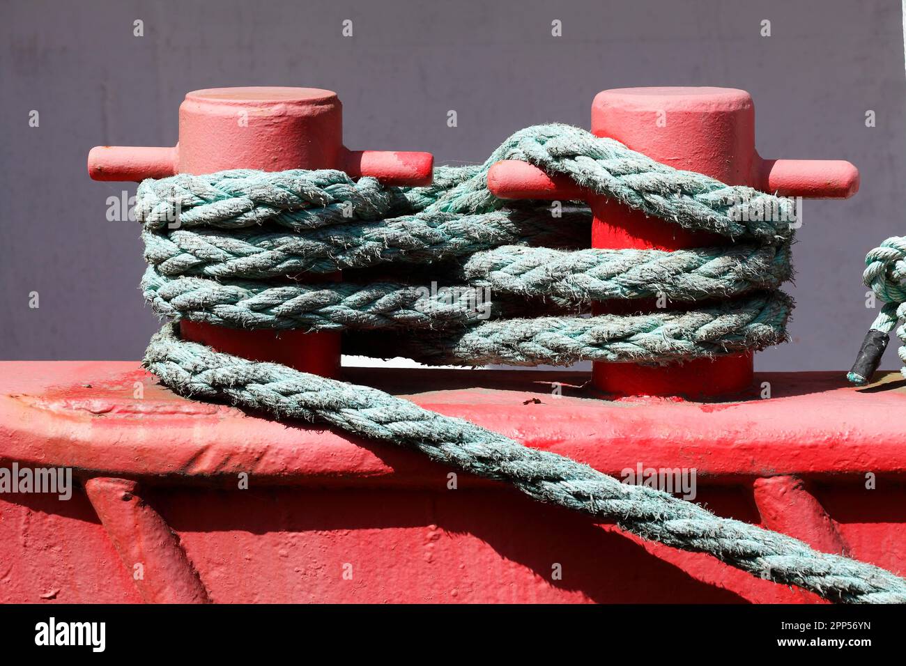 Red ship's bollard wrapped with ship's rope, mooring line, Germany ...