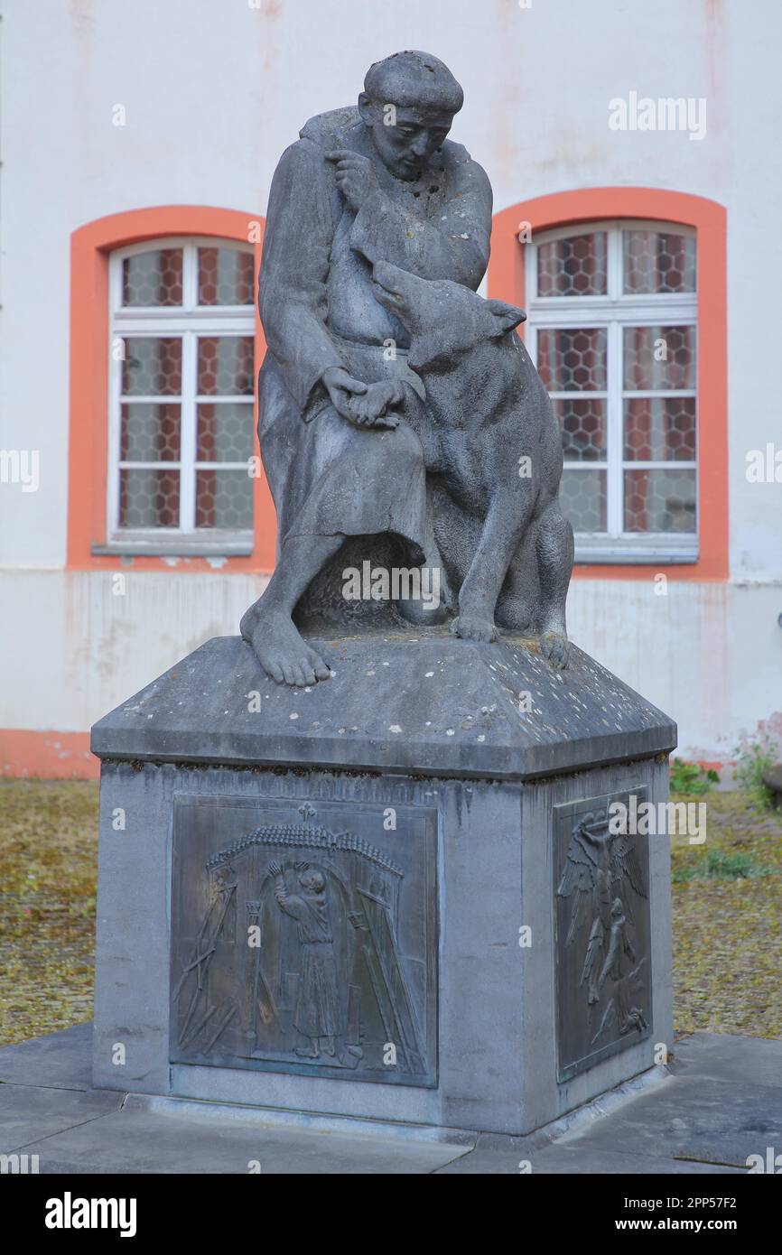 Monument with relief and sculpture of St. Francis with wolf figure at ...