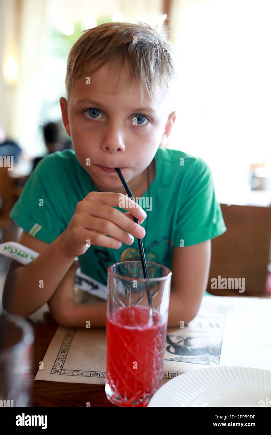 Child drinking juice through straw in restaurant Stock Photo - Alamy