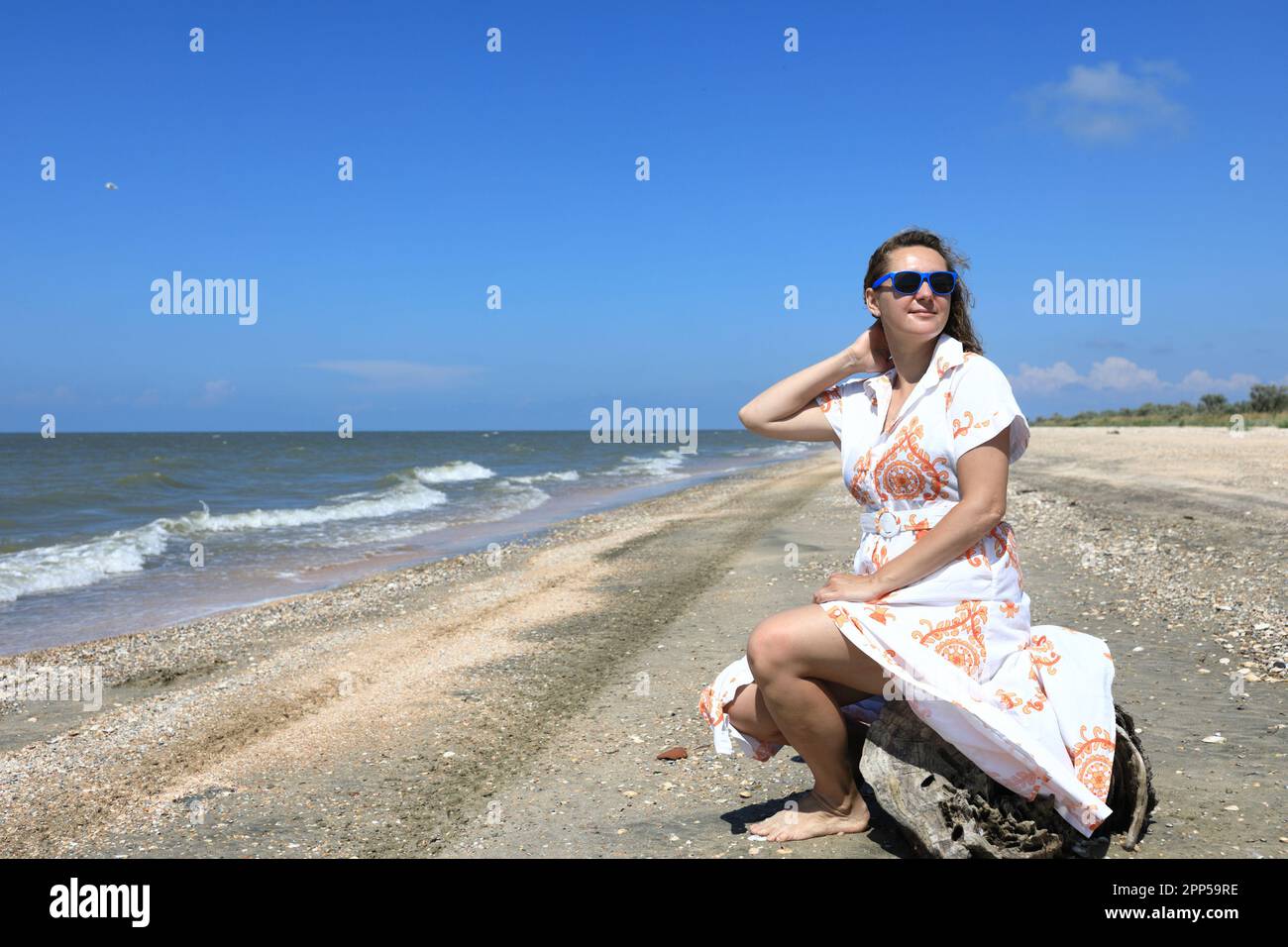 Woman sitting on beach of Sea of Azov, Primorsko-Akhtarsk Stock Photo ...