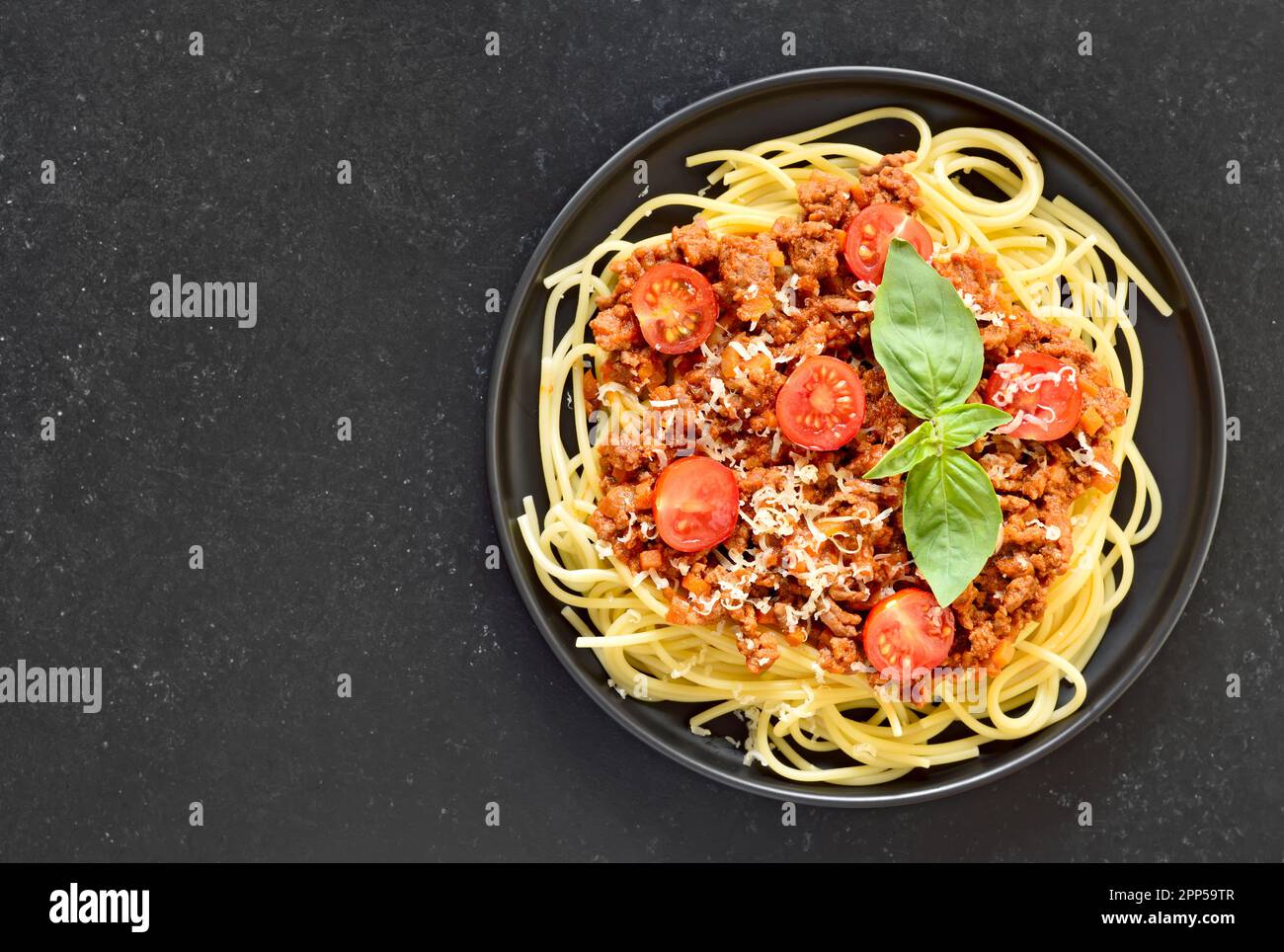Spaghetti bolognese pasta on plate over black stone background with ...