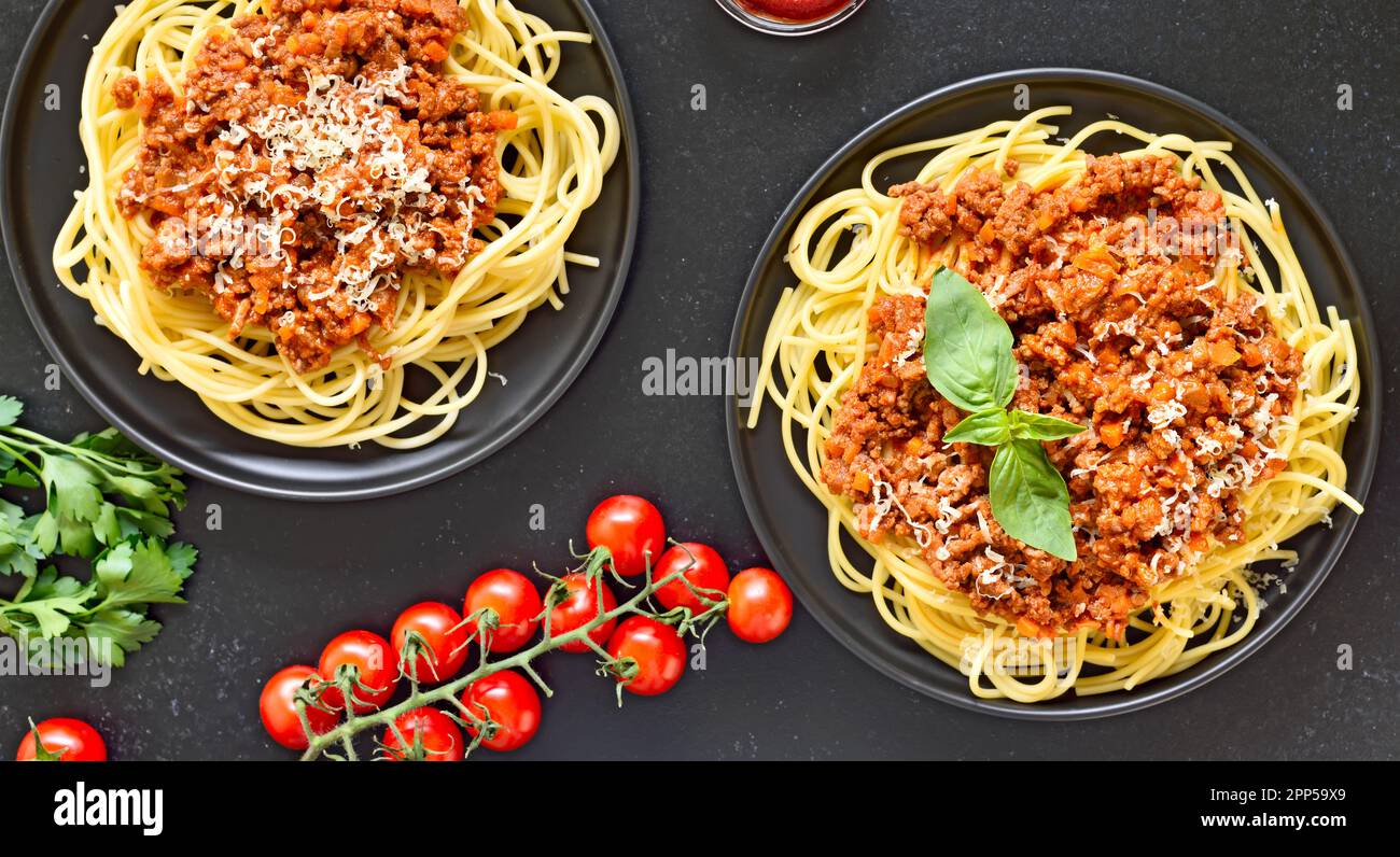 Spaghetti bolognese pasta on plate over black stone background. Top ...