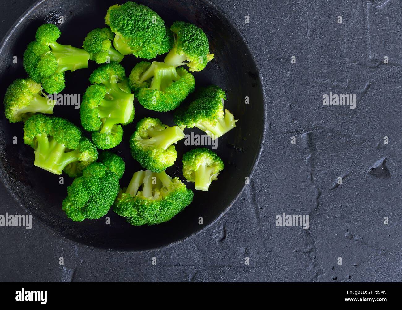 Broccoli on plate over black stone background. Vegan food. Top view ...