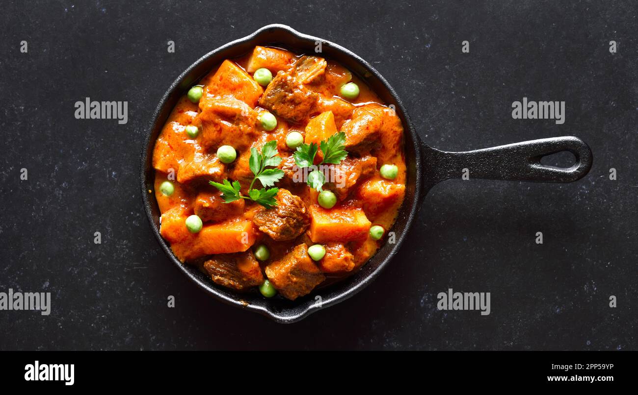 Beef stew with potatoes and carrots in tomato sauce over black ...