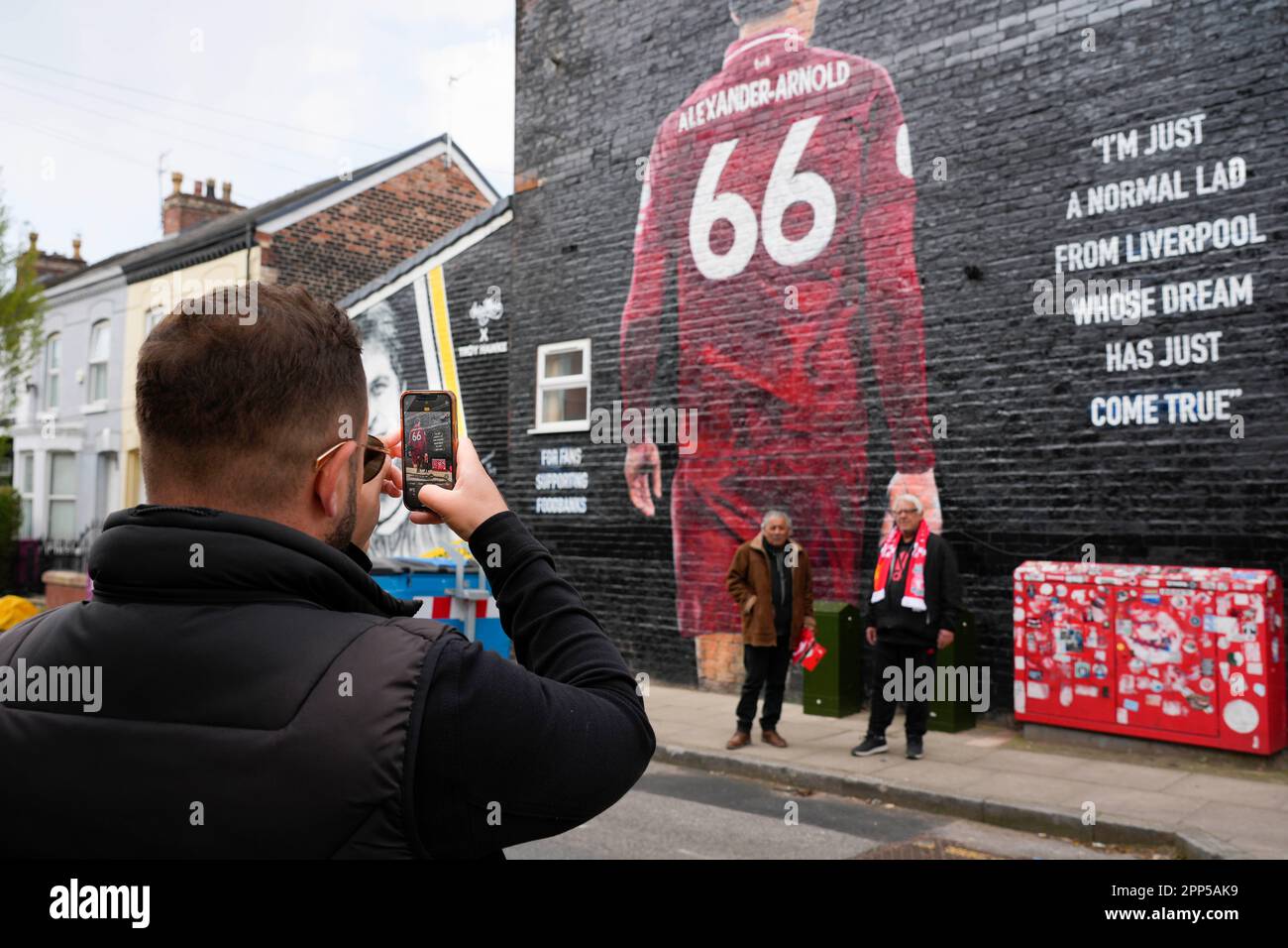 A fan takes a photo of his friends in front of a mural of Trent ...