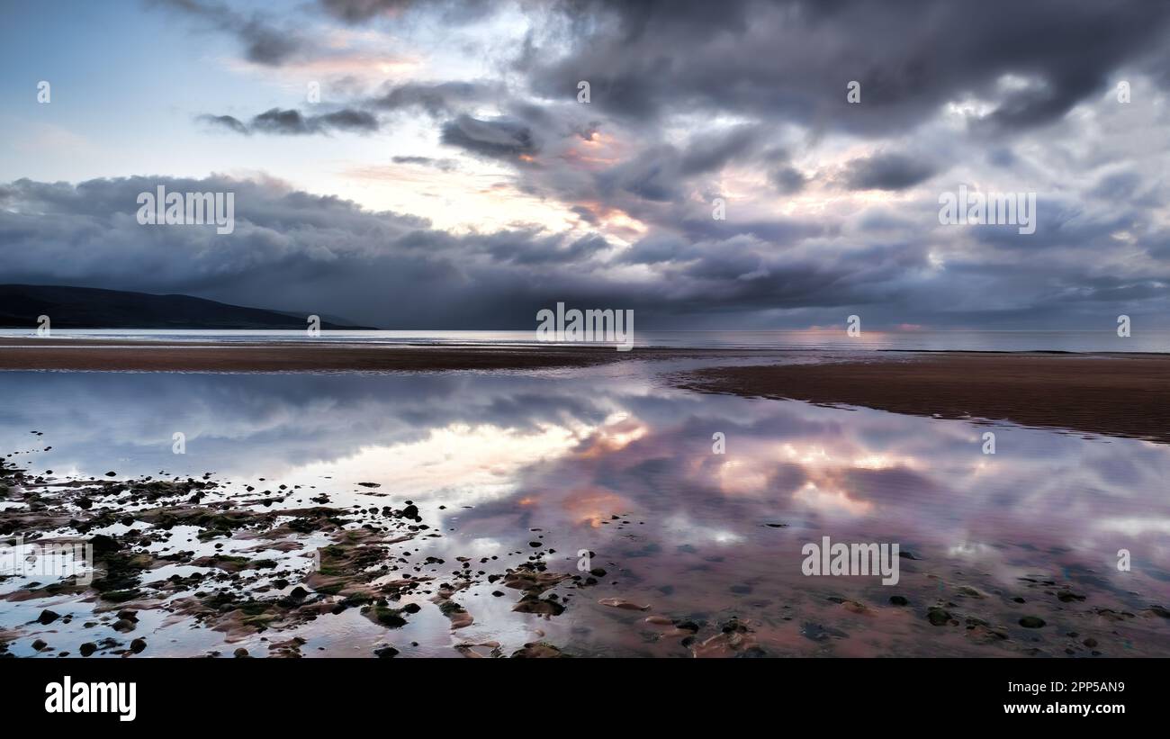 Dawn colours reflected in a pool of water on Brora beach in the ...