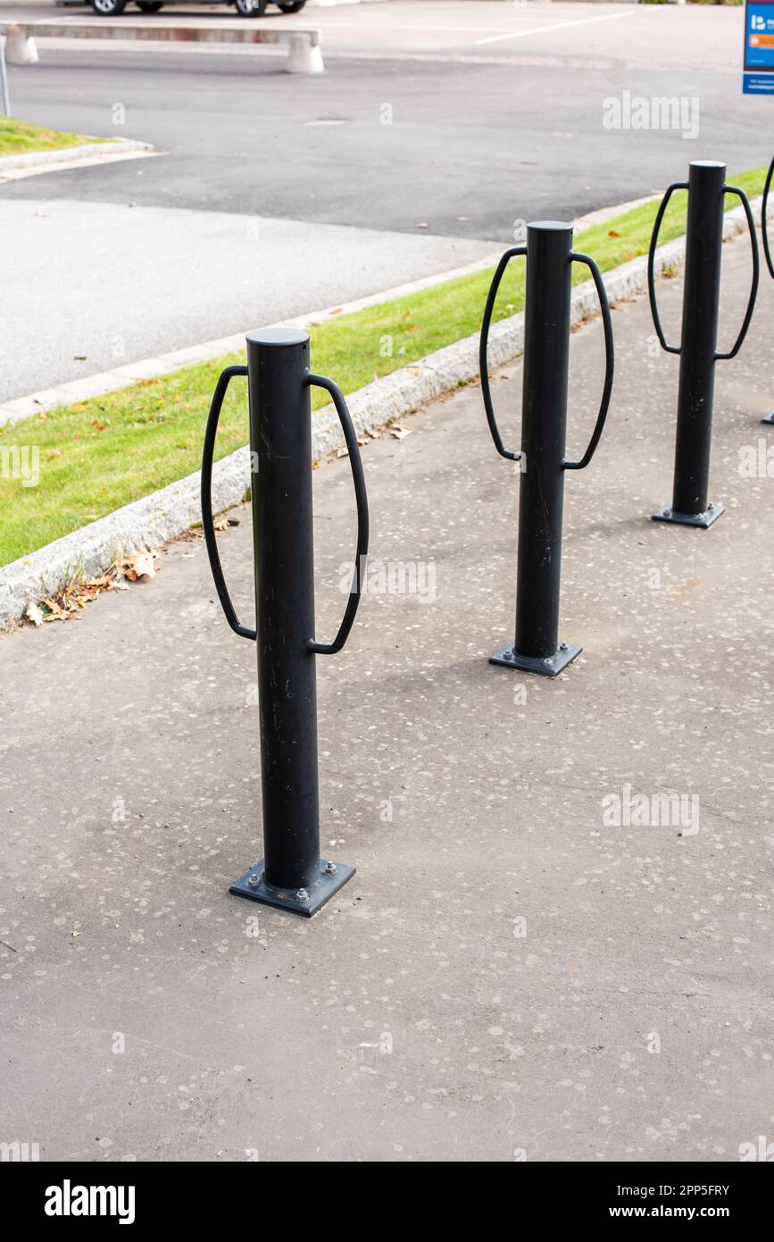 Three metal poles for locking bikes to Stock Photo - Alamy