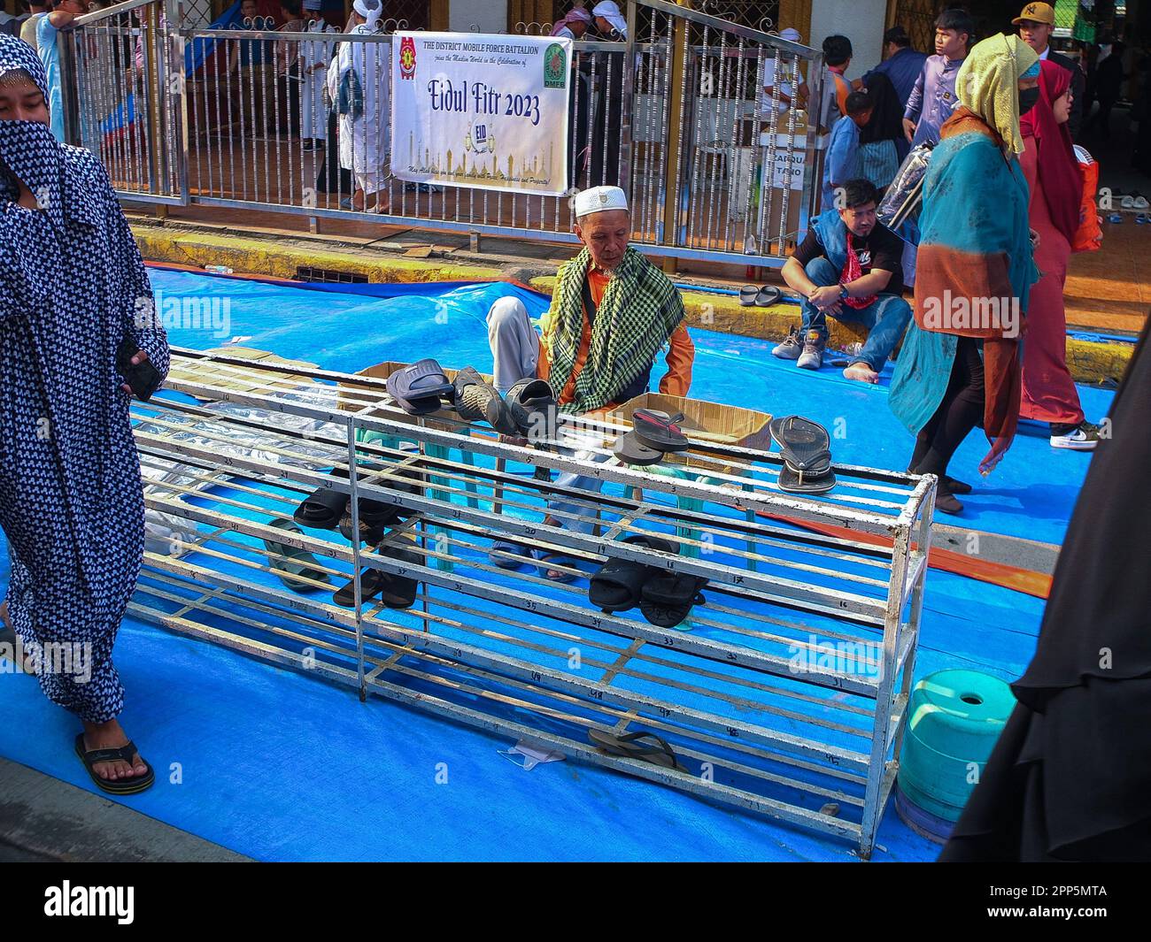 A Muslim man guards the shoes and slippers of the mosque-goers at the ...