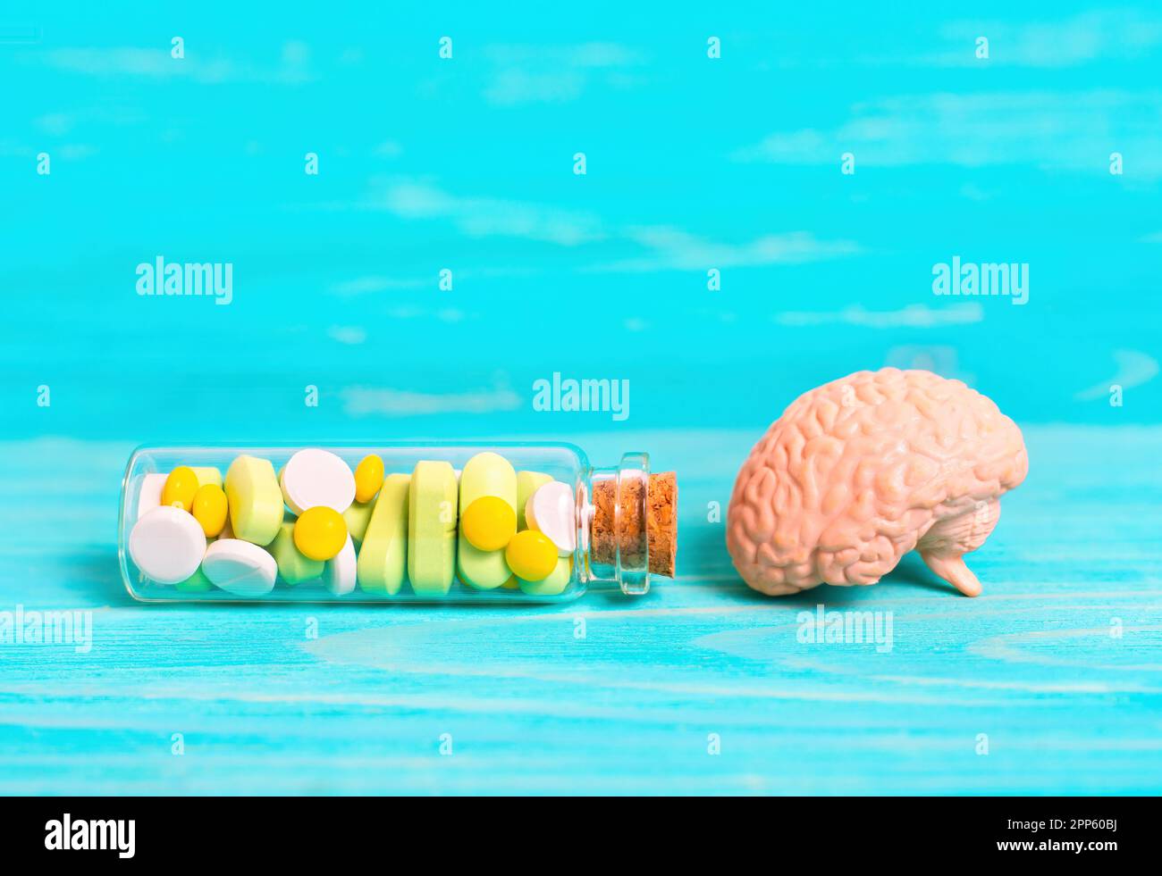 Detailed human brain model placed by a small glass bottle filled with ...