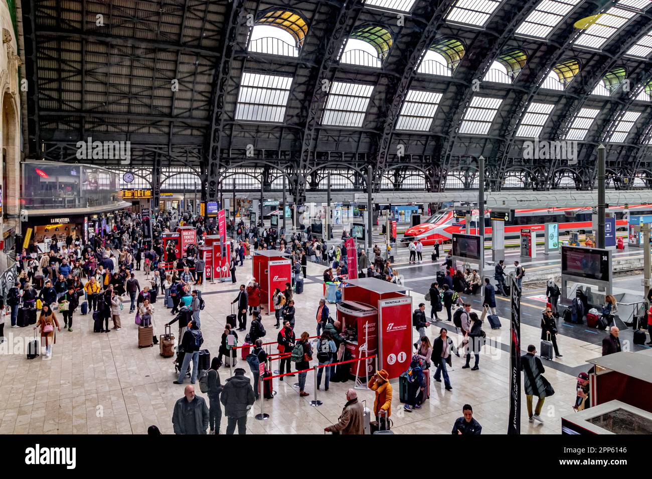 Rail passengers walking through the main concourse of Milano Centrale ...