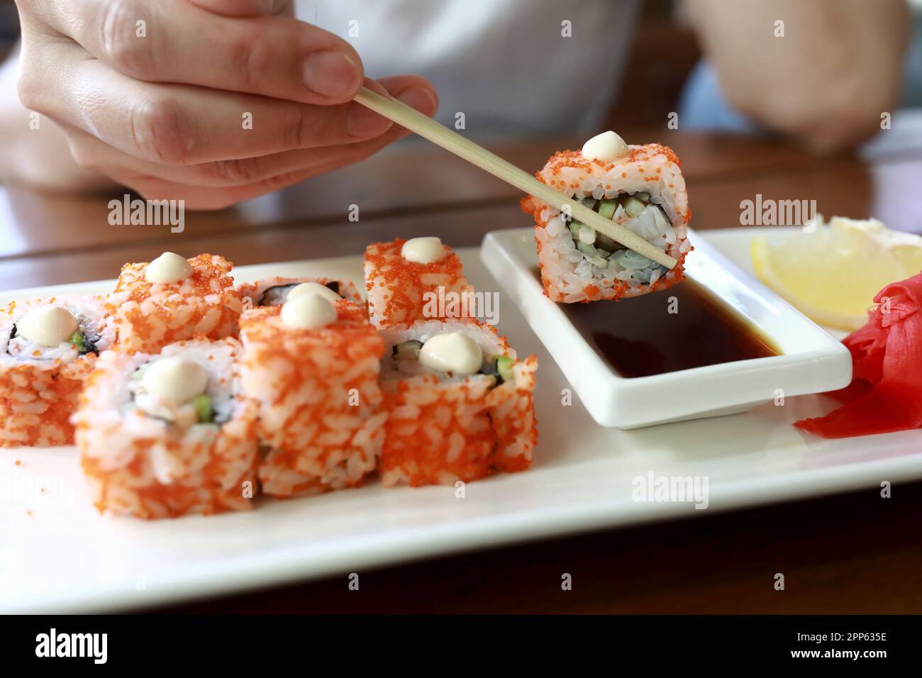 Woman dipping delicious sushi hi-res stock photography and images - Alamy