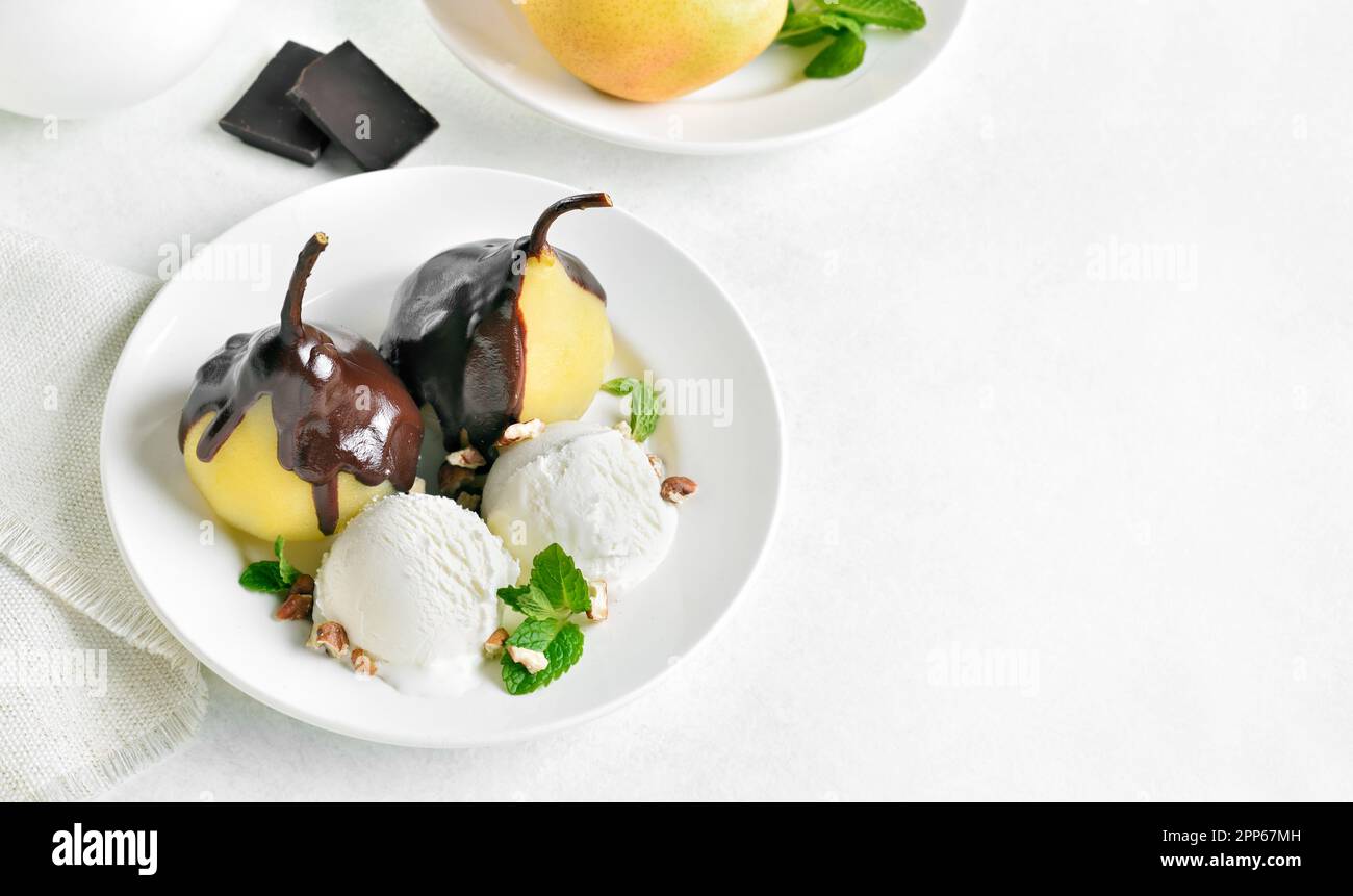 Poached pears with chocolate sauce and ice cream on white background ...