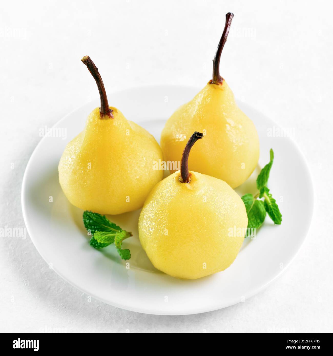 Poached pears on plate over white background. Close up view Stock Photo ...