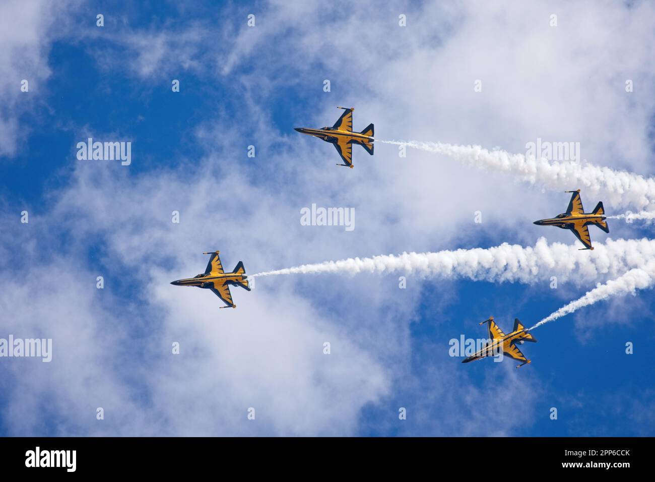 Four military jets soar through the sky in formation, leaving trails of ...