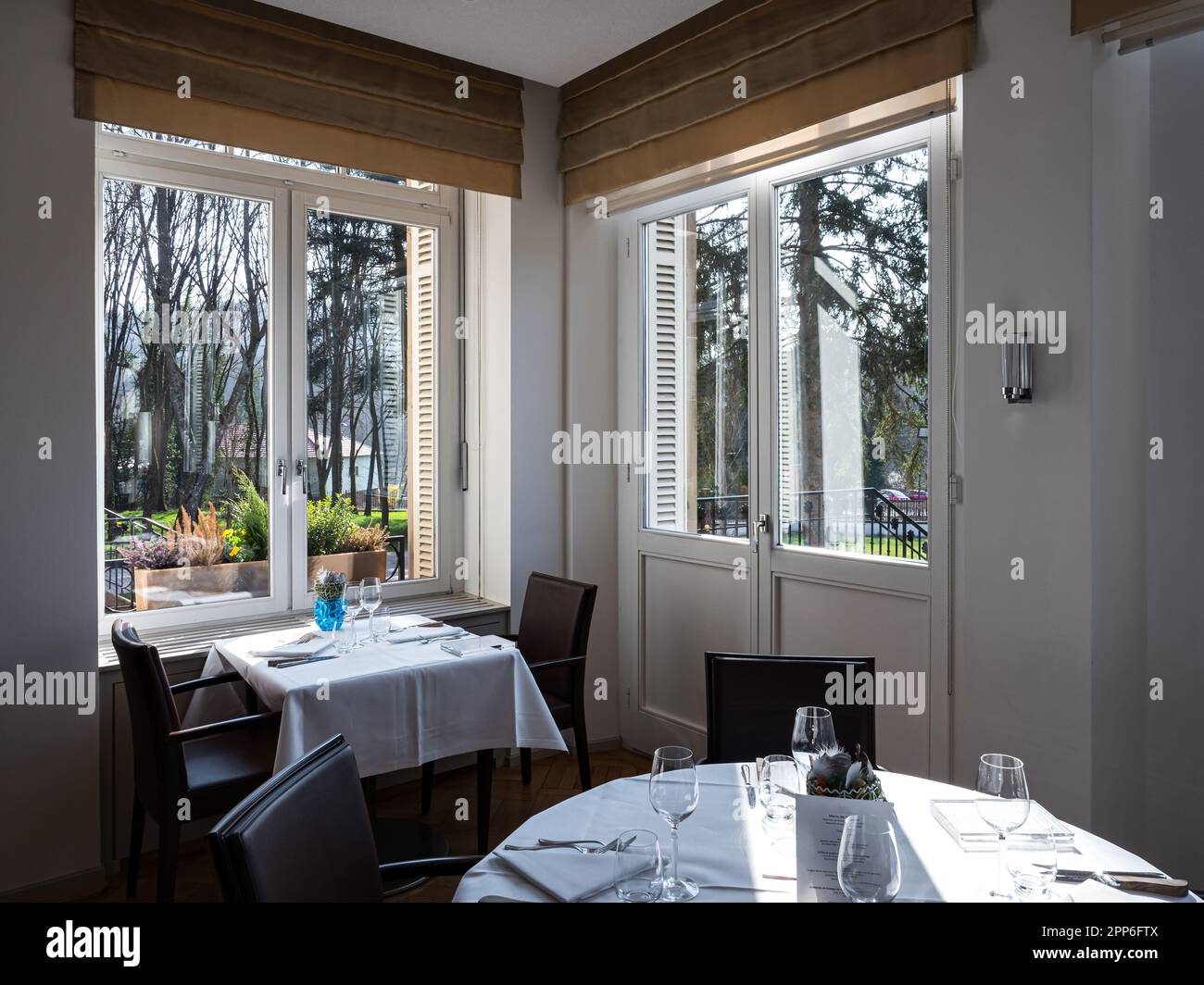 Cozy restaurant interior. Space filled with the morning sun. Tables are ...