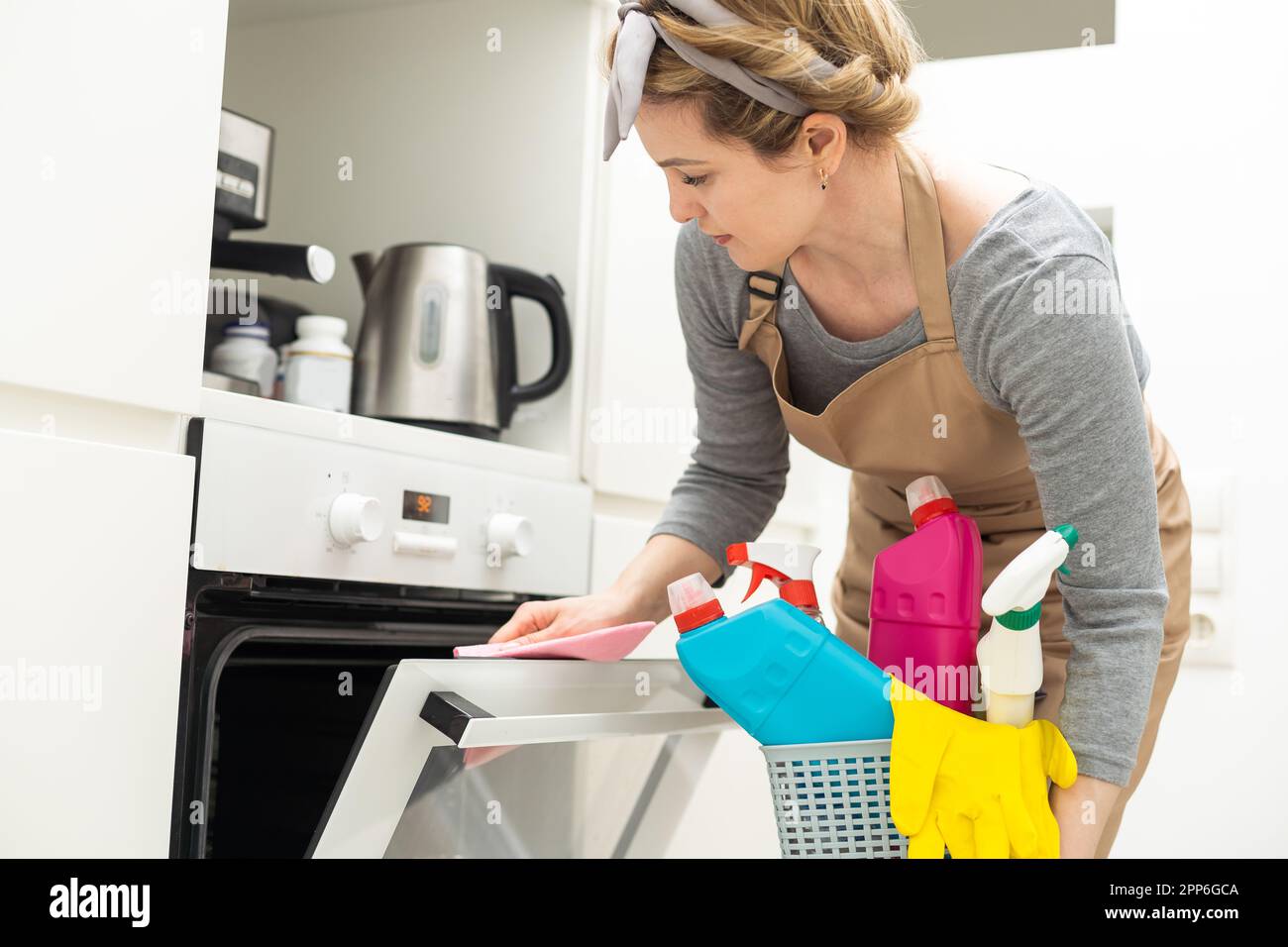 Attractive woman cleaning furniture in kitchen with a rag Stock Photo ...