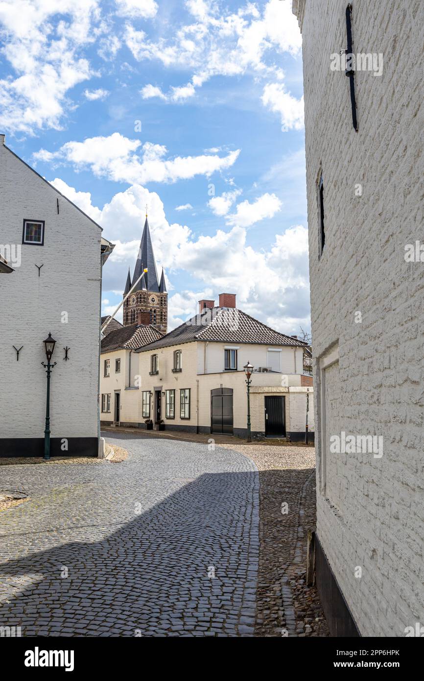 Landscape of curved cobbled street between house with white walls ...