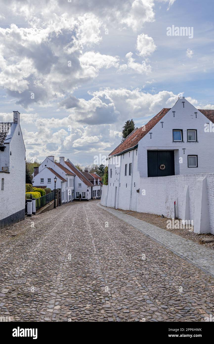 Landscape of cobbled street between houses with white walls against ...