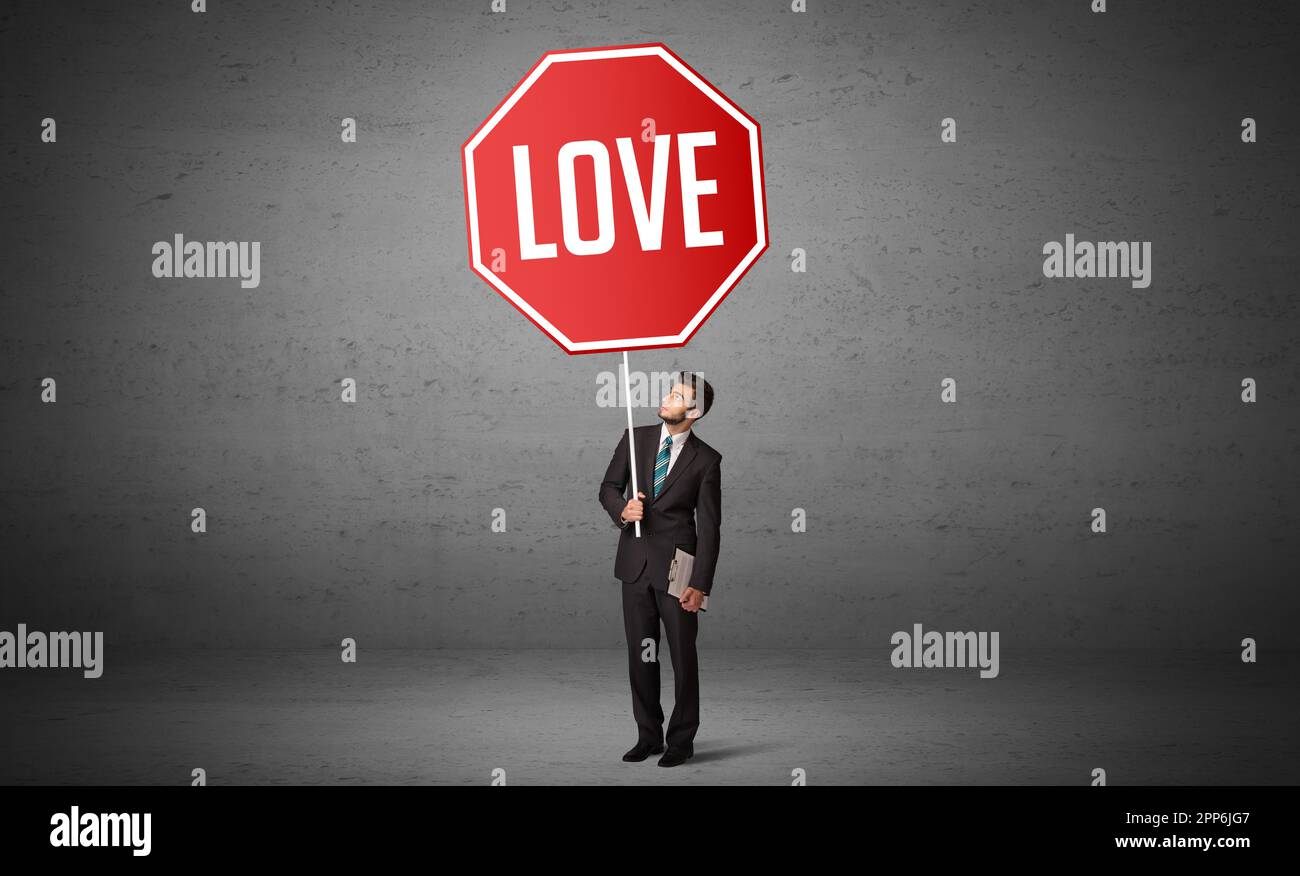 Young business person holding road sign Stock Photo - Alamy