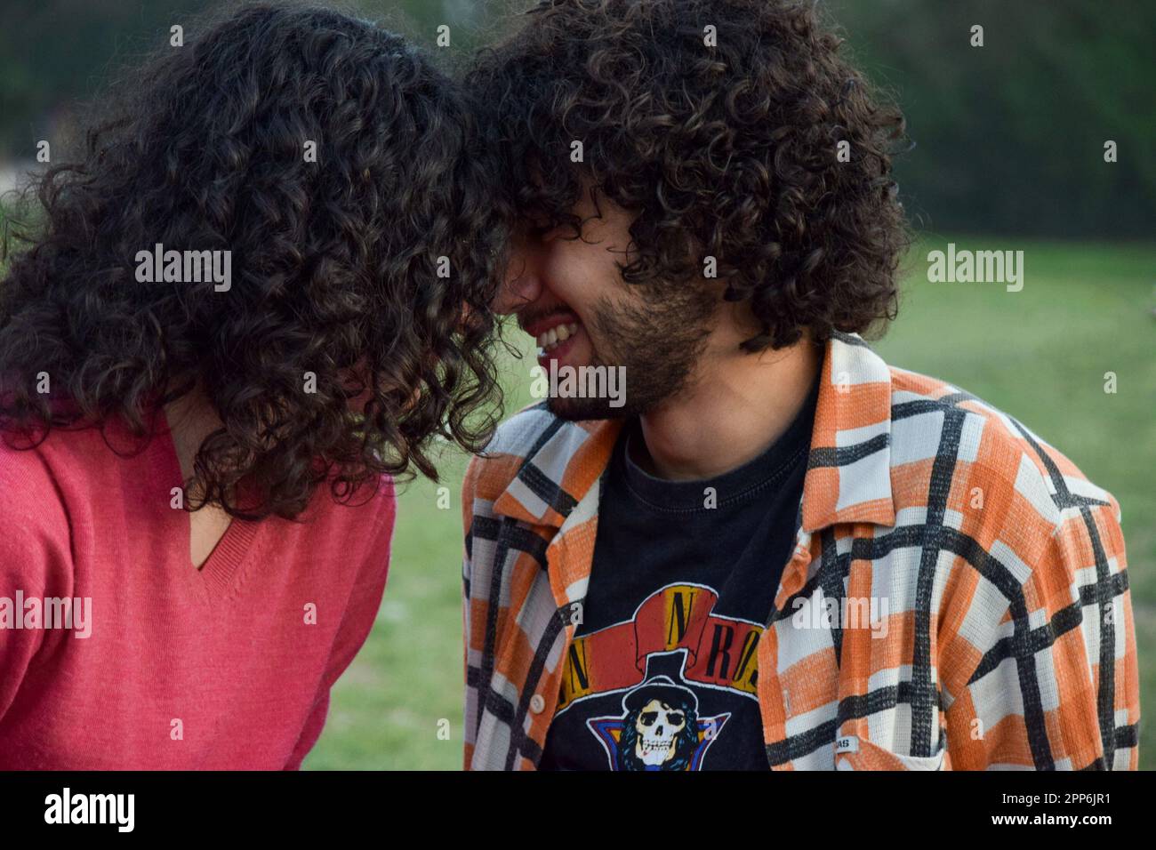 Romantic couple sitted at the park in the moment of kissing Stock Photo ...