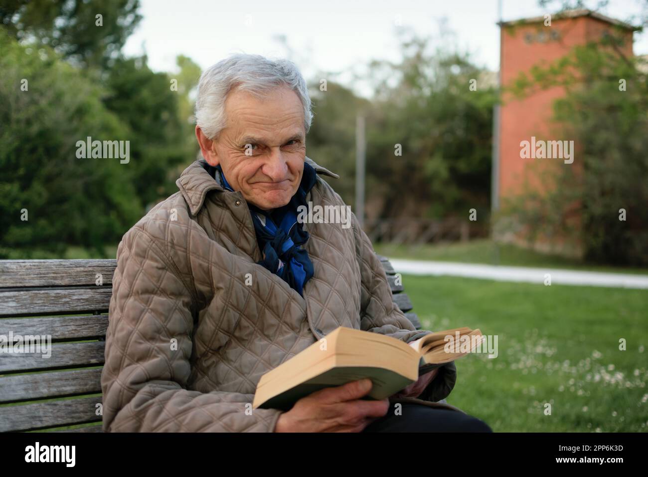 Old man with gray hair reading a book sited on an bench Stock Photo - Alamy