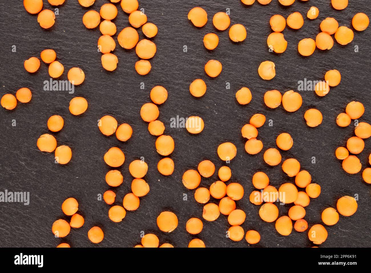Red lentils on a slate stone, macro, top view Stock Photo - Alamy