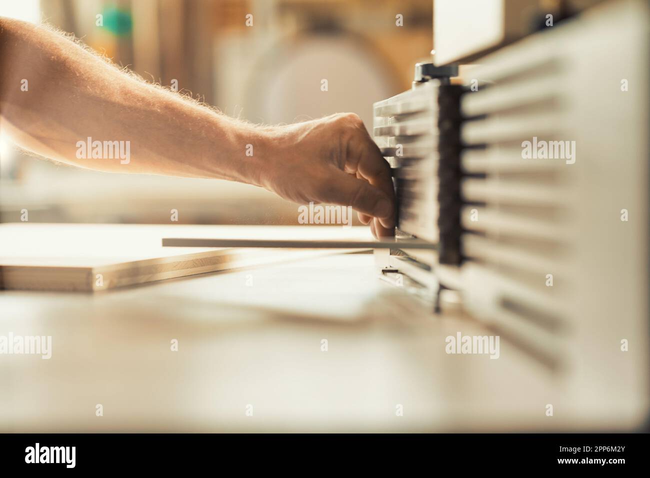 A carpenter's strong and muscular hand and forearm holding a metal tool ...