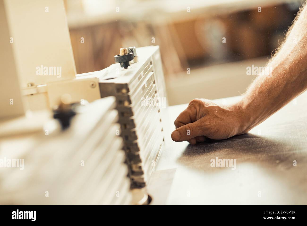 A carpenter's strong and muscular hand and forearm holding a metal tool ...
