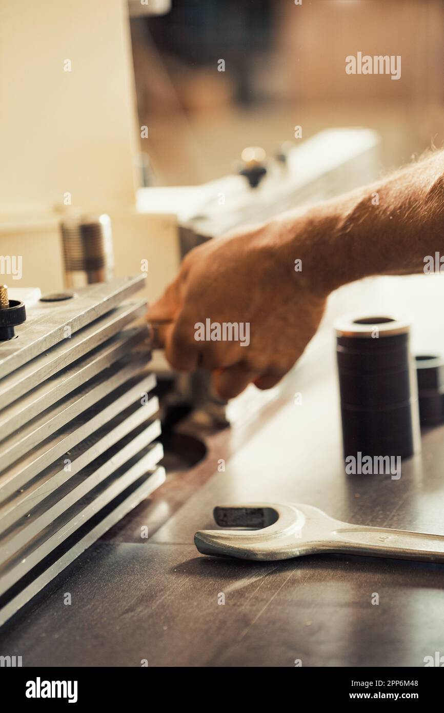 A carpenter's strong and muscular hand and forearm holding a metal tool ...