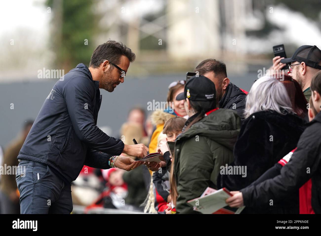 Wrexham co-owner Ryan Reynold signs autographs for fans ahead of the ...
