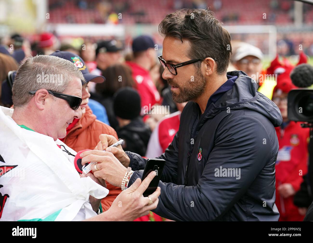 Wrexham co-owner Ryan Reynolds signs autographs for fans ahead of the ...